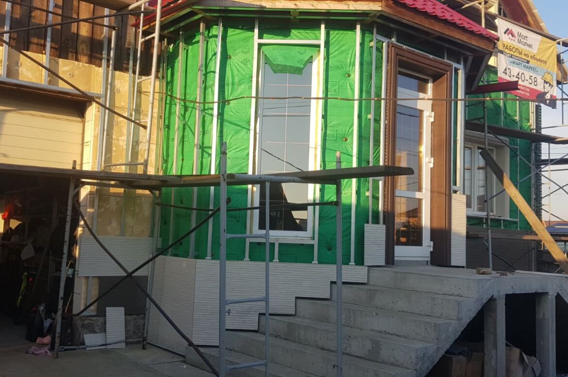 Фасад из японских фиброцементных панелей с цоколем из натурального камня.